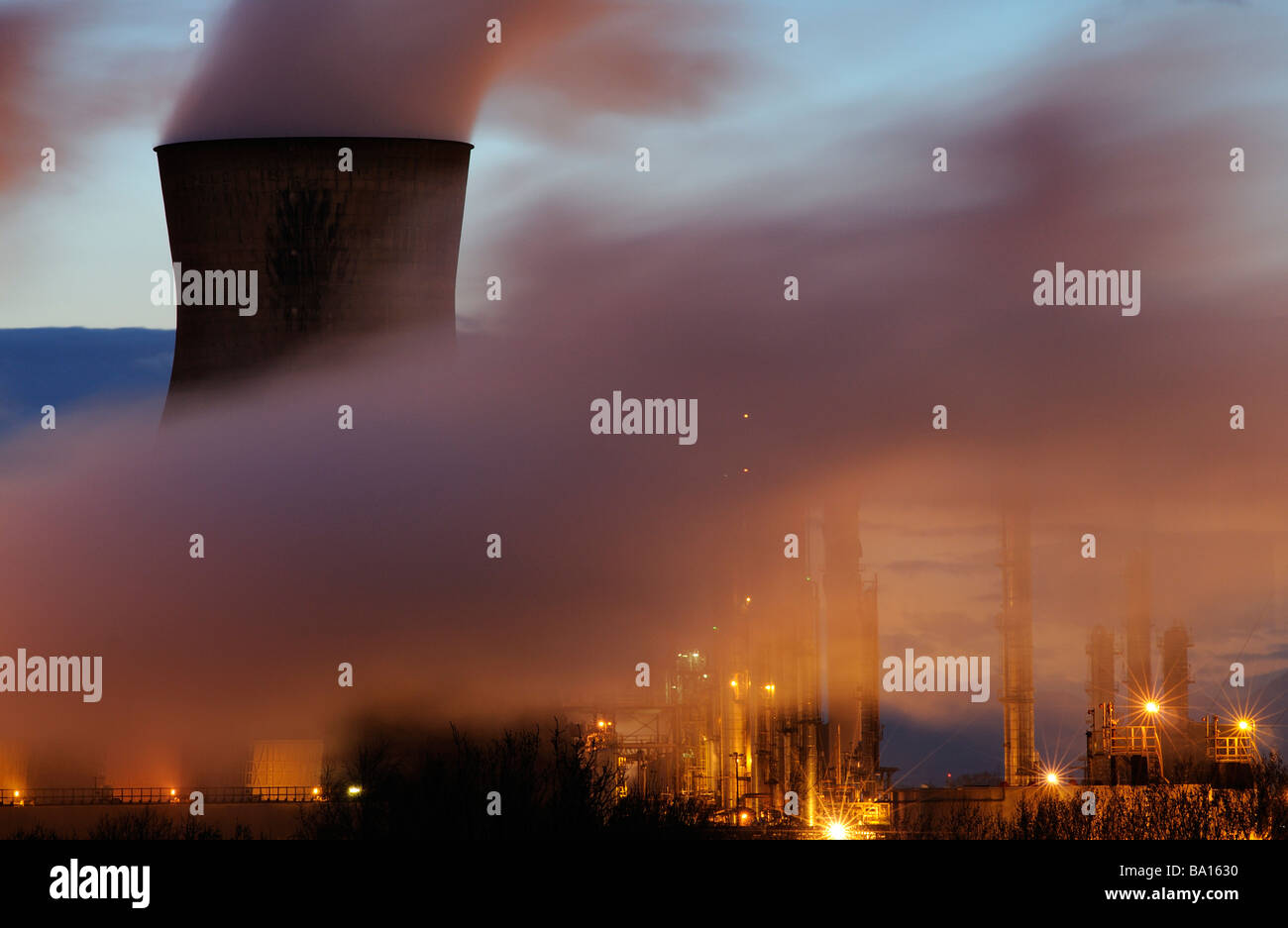 Steam billows from cooling towers at the petrochemical refinery in ...