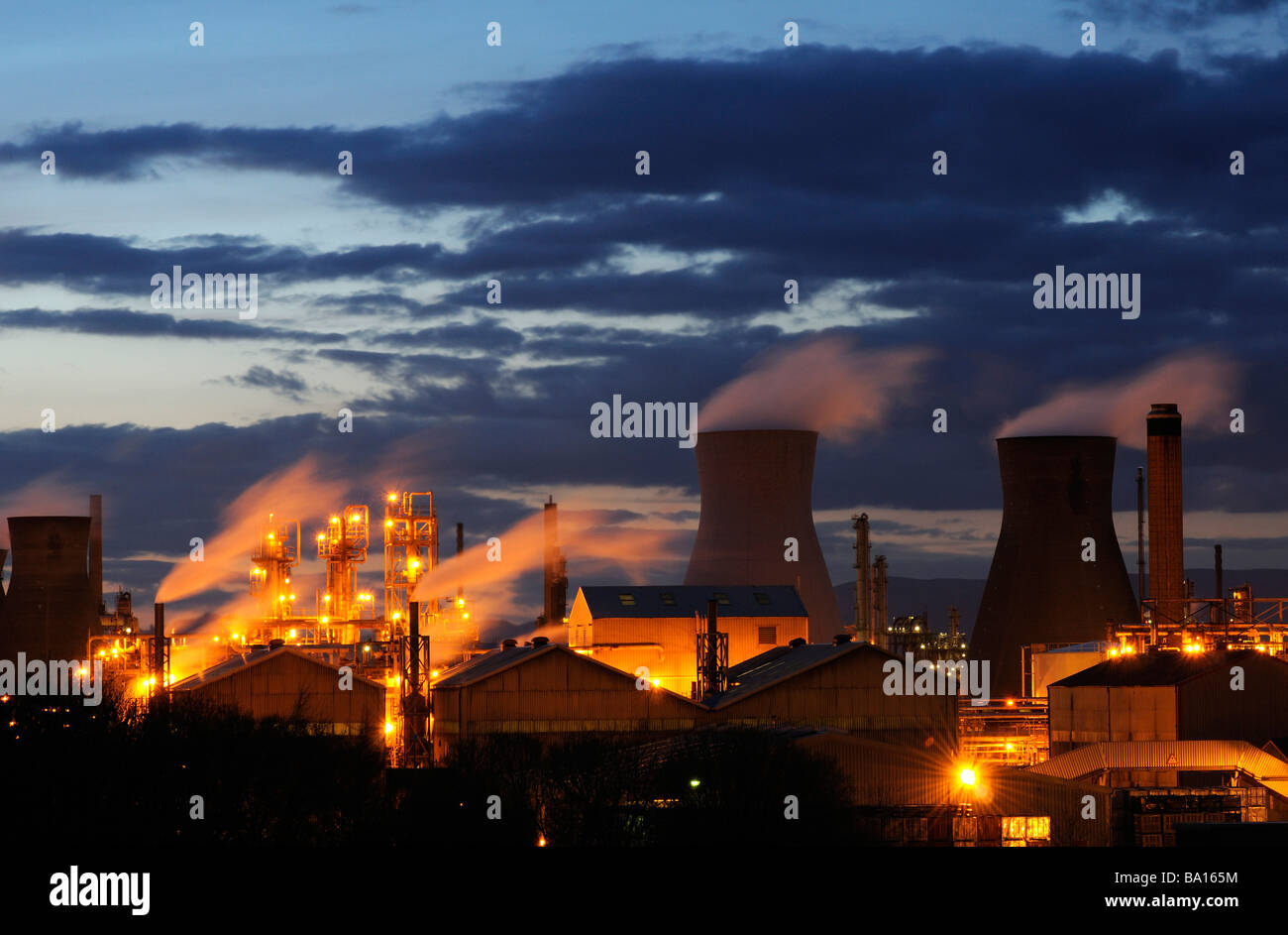 Steam billows from cooling towers at the petrochemical refinery in ...