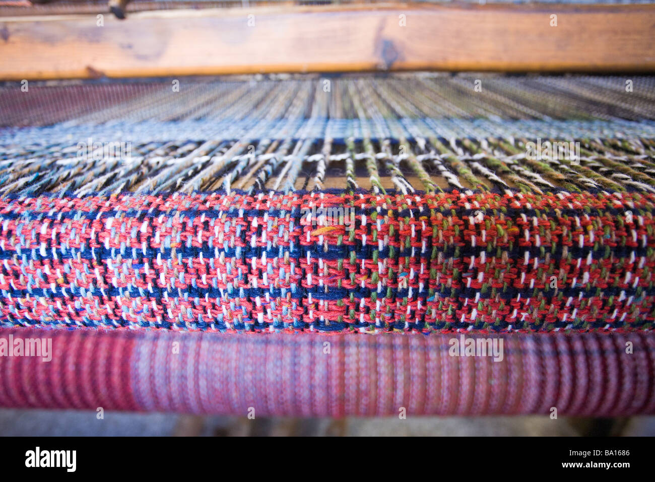 Loose Woven Tweed on the Loom. A red, blue and green tweed being woven ...