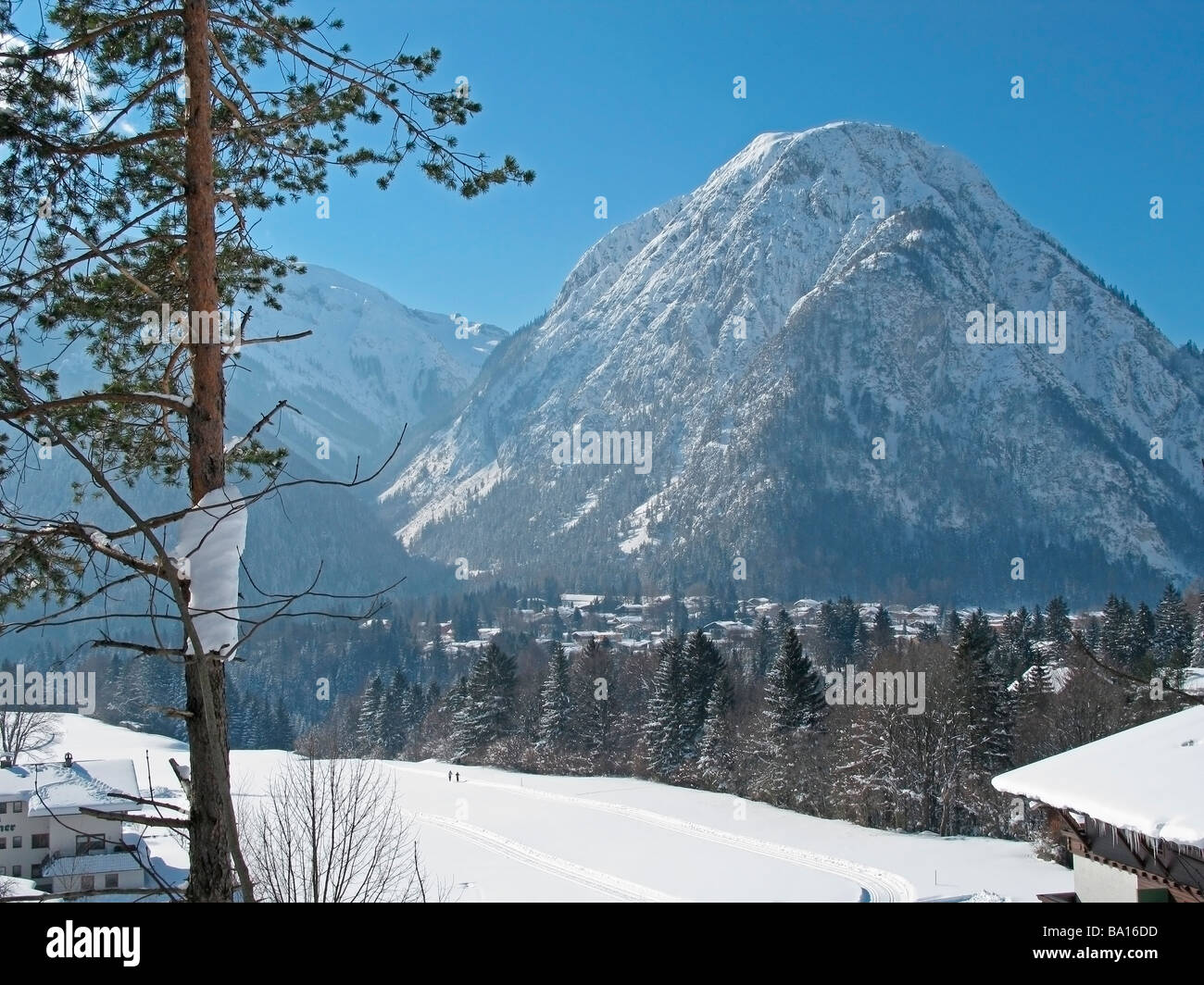 Village at the footage of Tirol mountains in fir woodland in blue ski ...