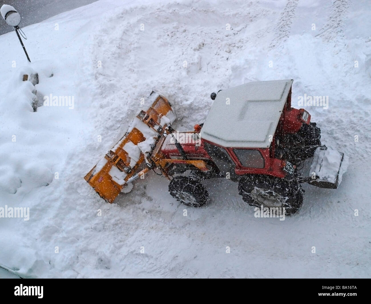 Red Tractor cleaning path from snow Stock Photo - Alamy