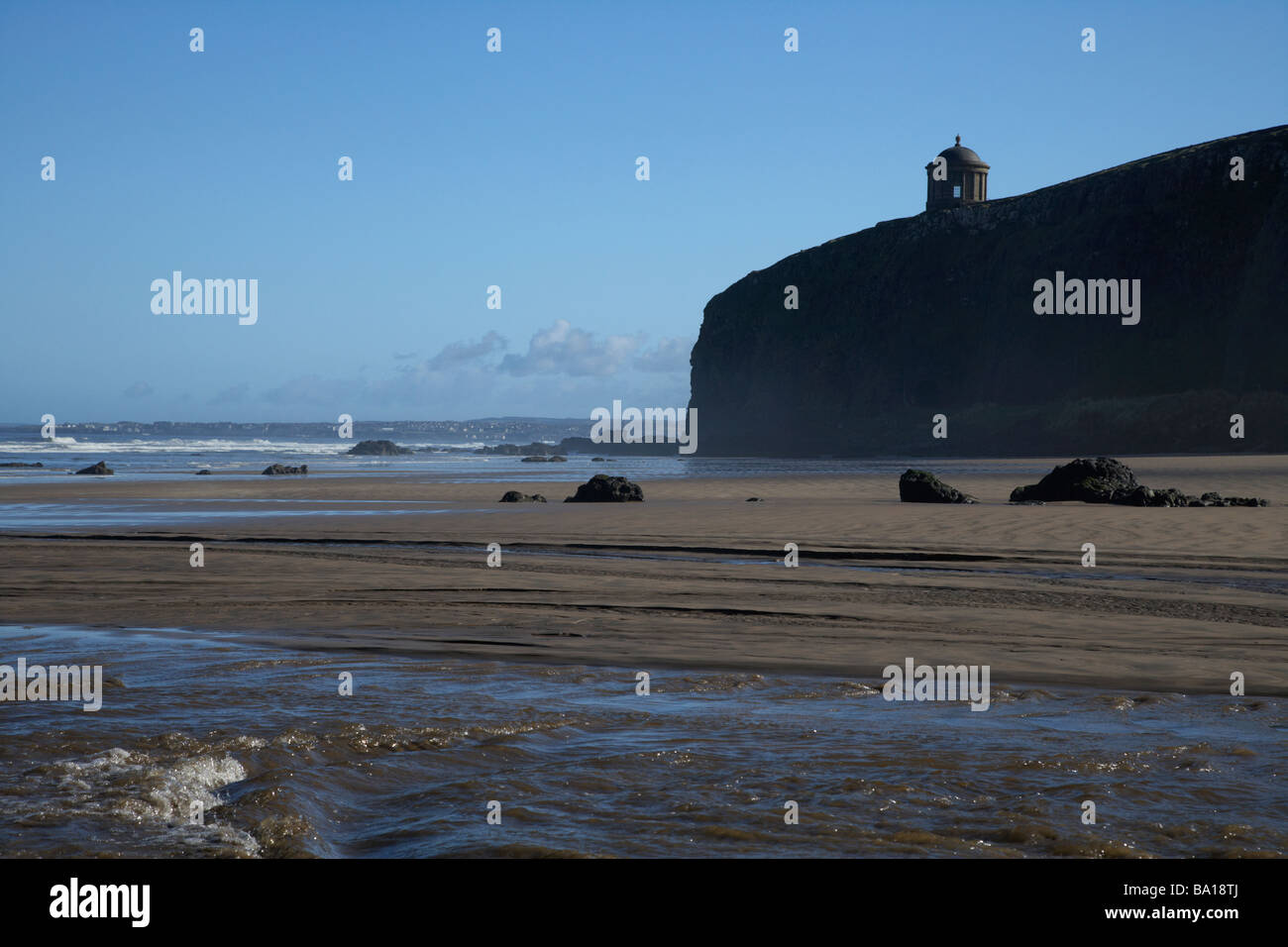 river running through Benone beach and Mussenden Temple on clifftop ...