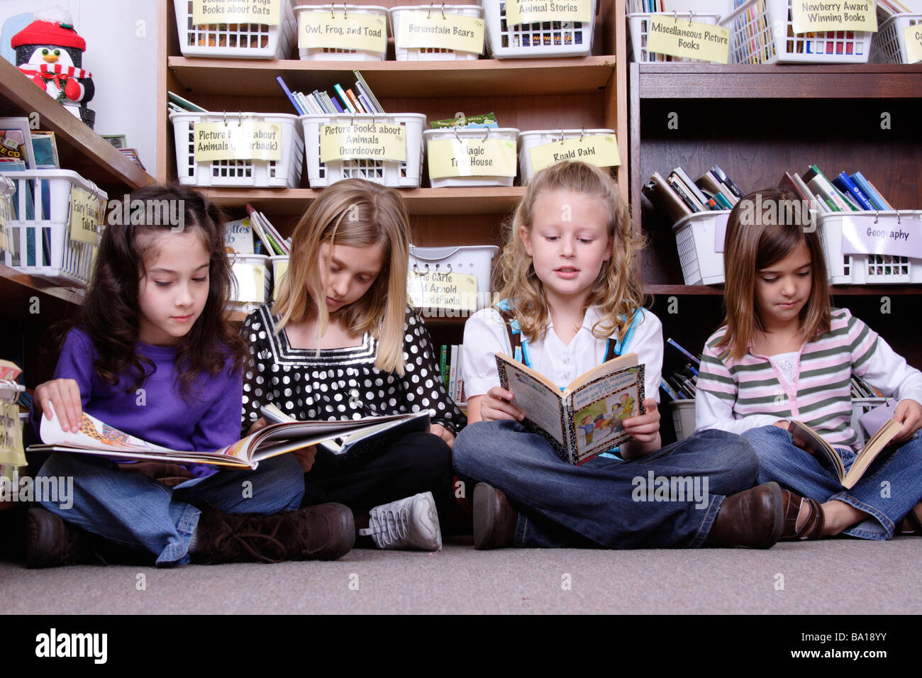 Grade schoolers reading in the class library Stock Photo - Alamy