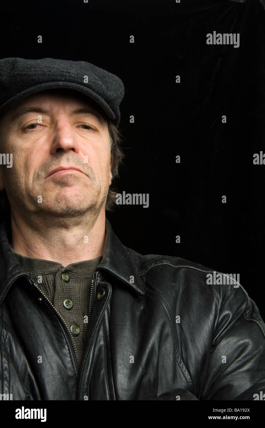 Tough looking man in a dark doorway Stock Photo - Alamy