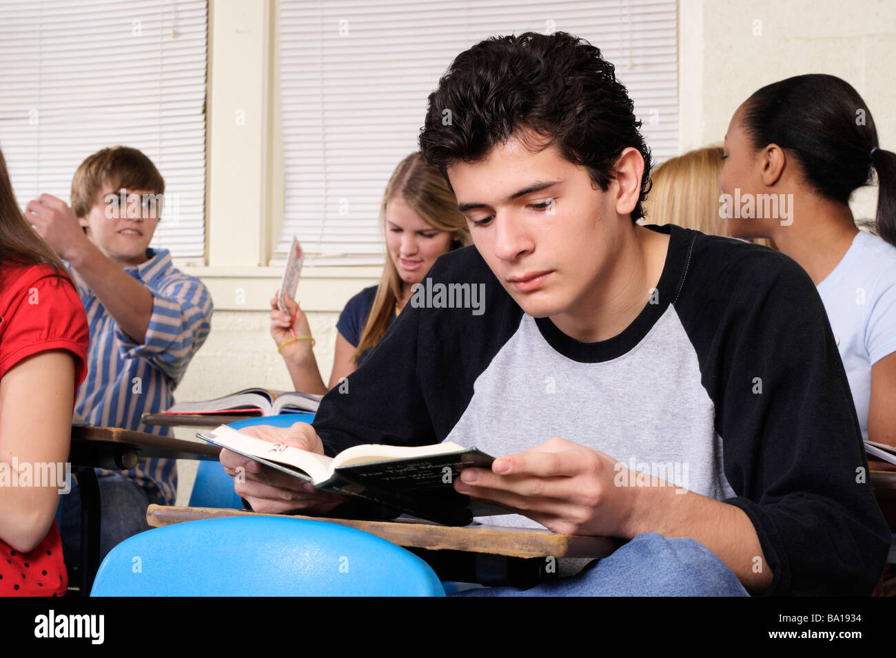 Student at desk reading Stock Photo - Alamy