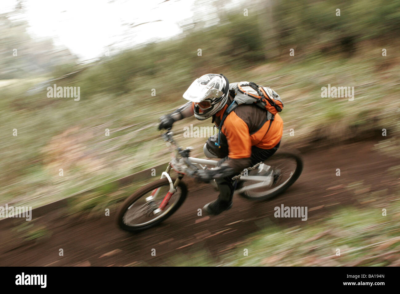 A downhill bike rider rides around a berm Stock Photo - Alamy