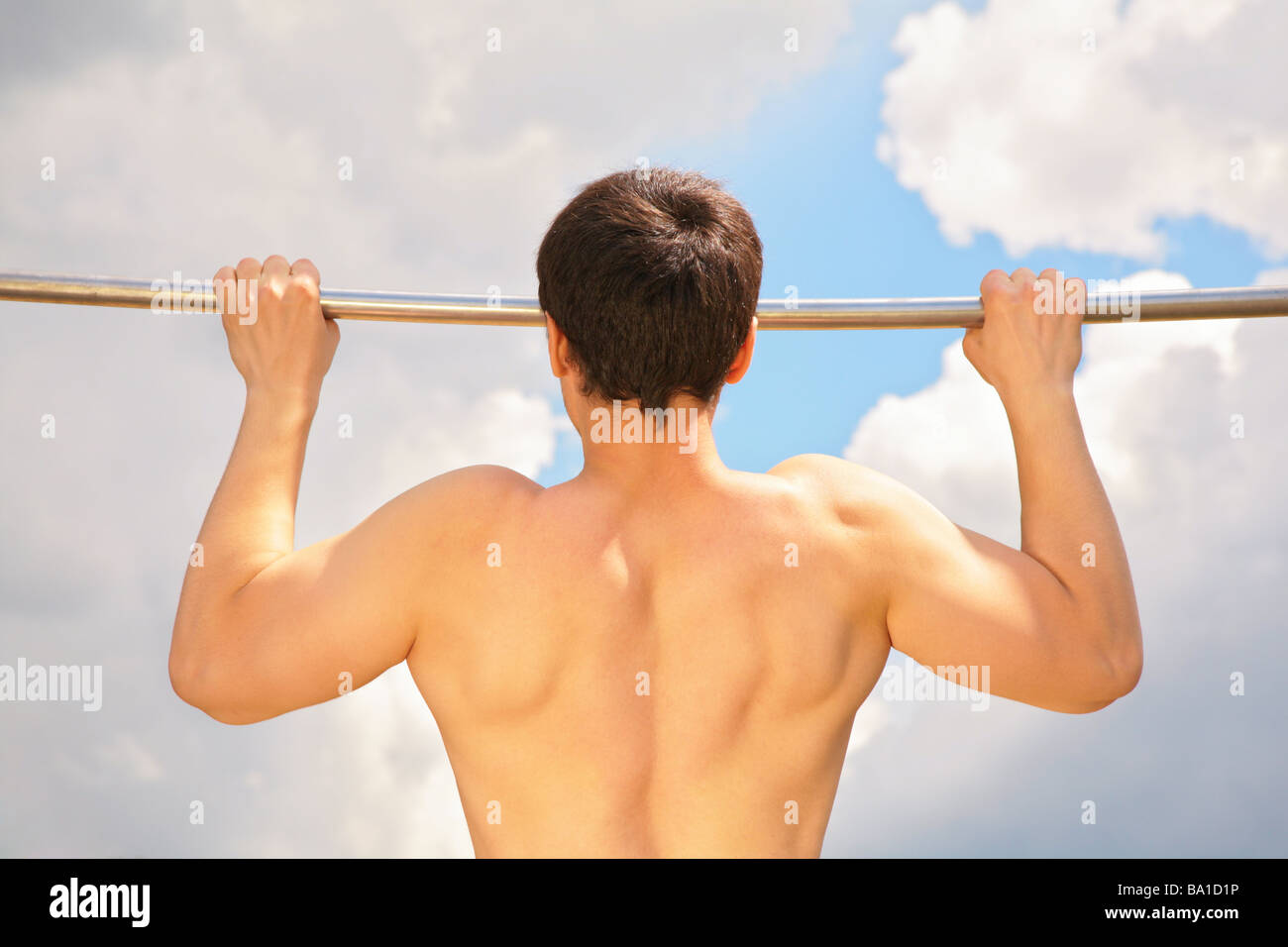 Athlete pull oneself up on sky background Stock Photo - Alamy