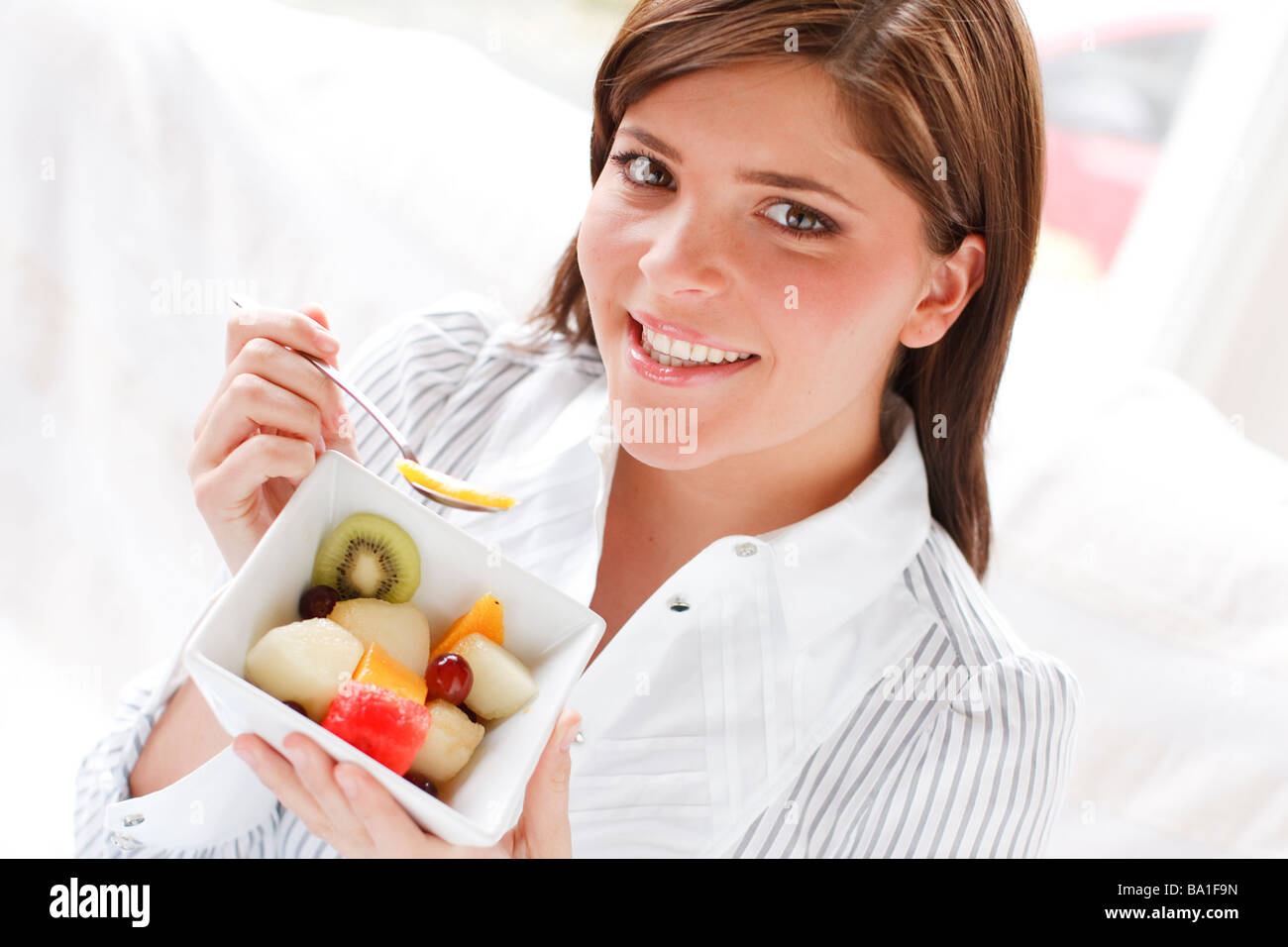 Girl eating fruit salad Stock Photo - Alamy
