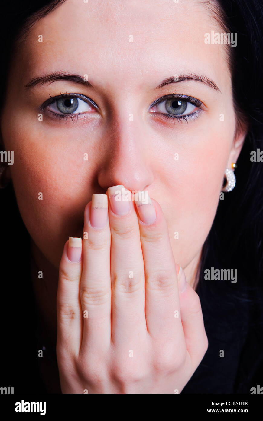 Young woman hand over mouth Stock Photo - Alamy
