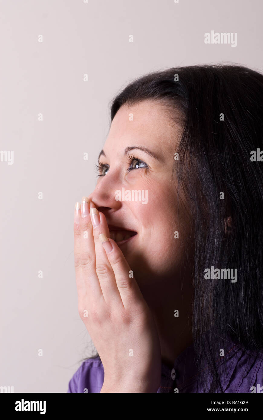 Beautiful young woman looking up laughing Stock Photo - Alamy