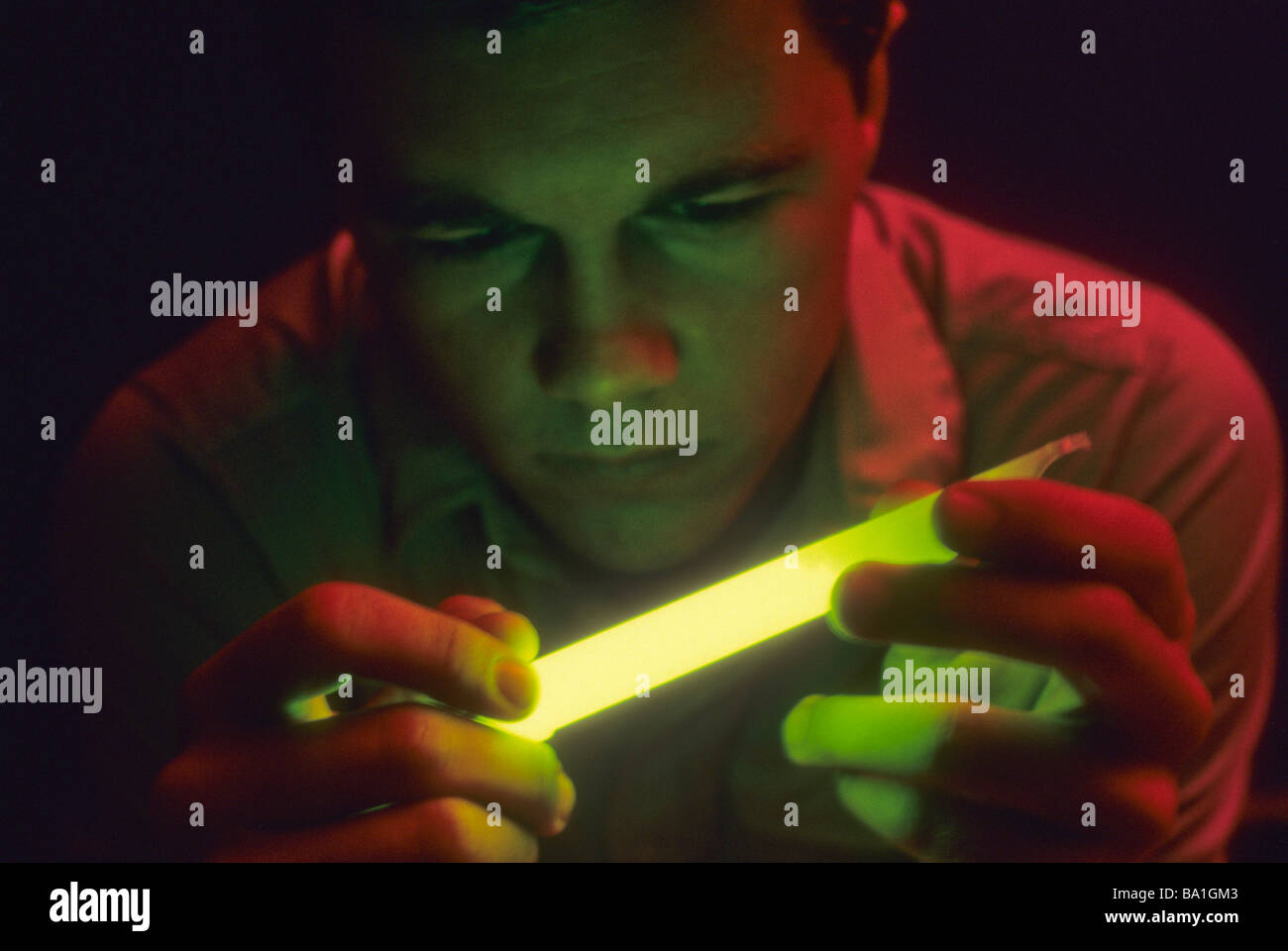 Young man examine glow light from chemical stick emergency fluorescent ...