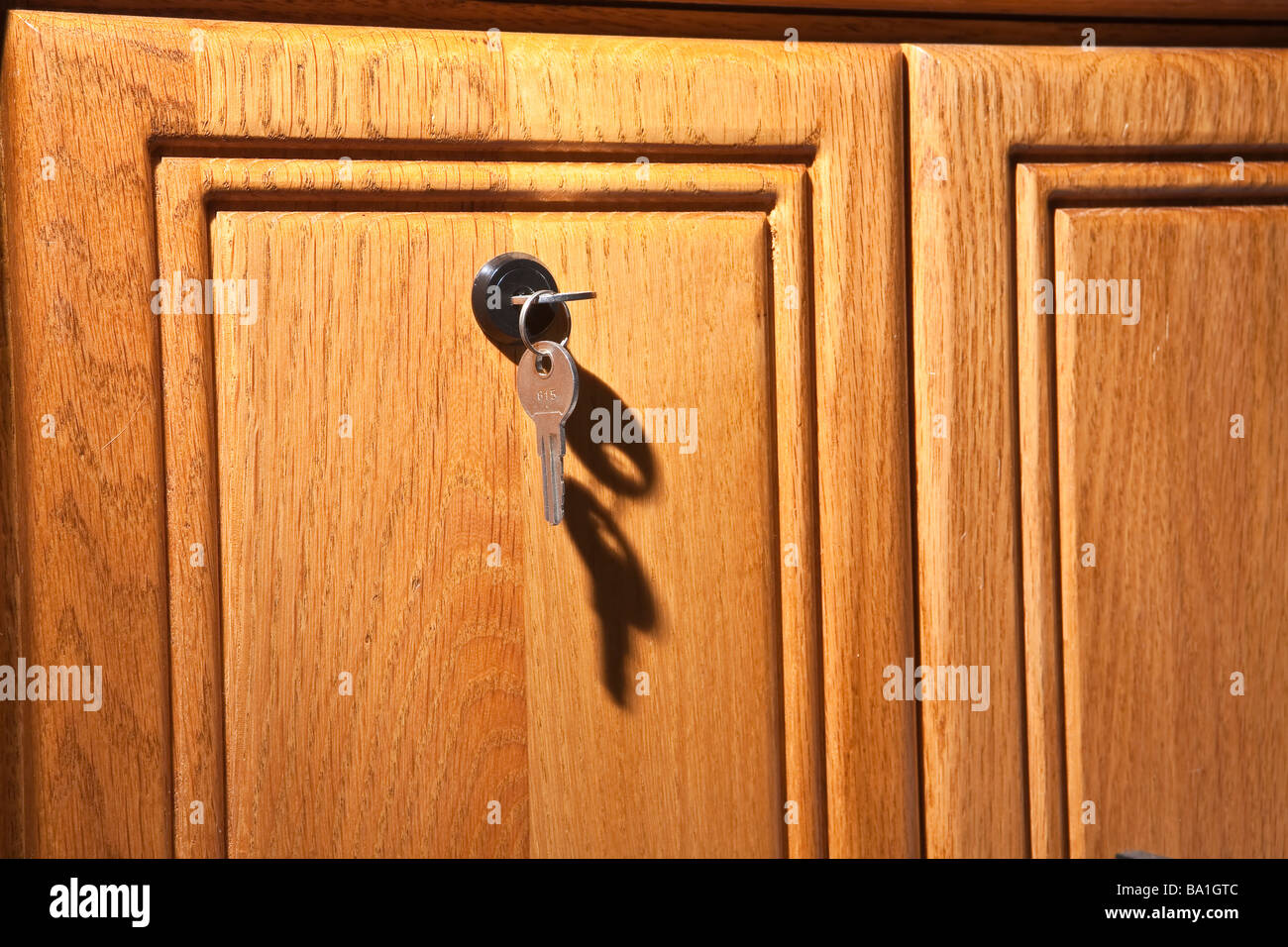 Two keys in lock of wooden desk door Stock Photo - Alamy