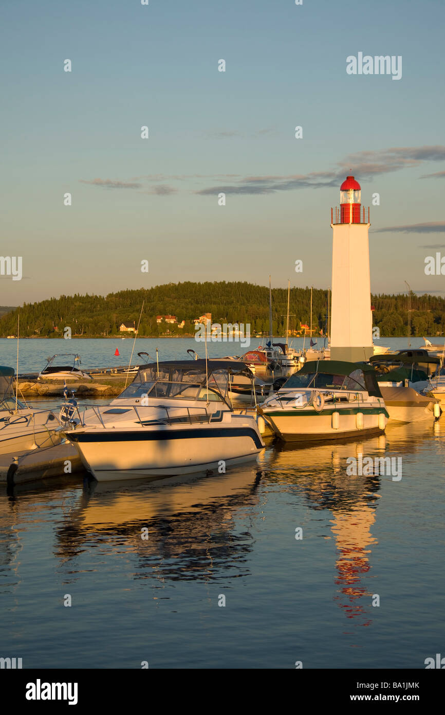 Boats docked and lighthouse Stock Photo - Alamy