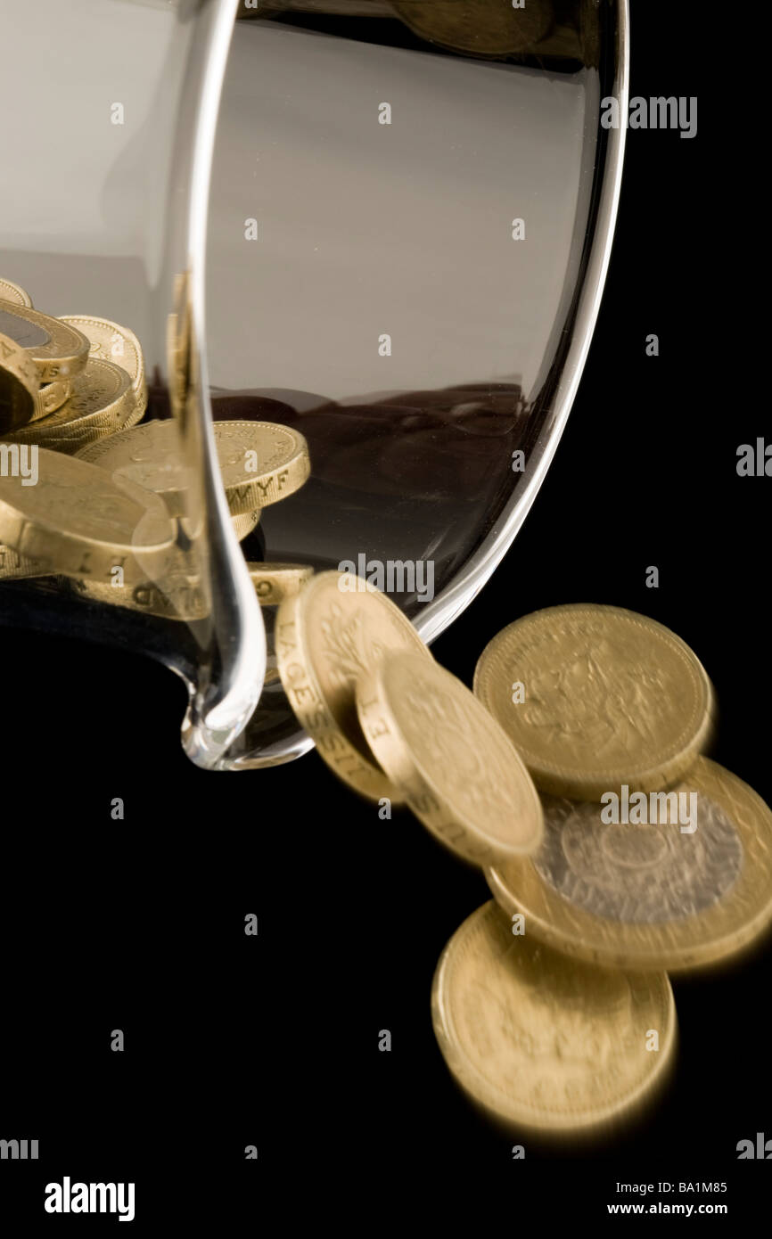 One pound and two pound coins pouring out of a glass jug Stock Photo ...