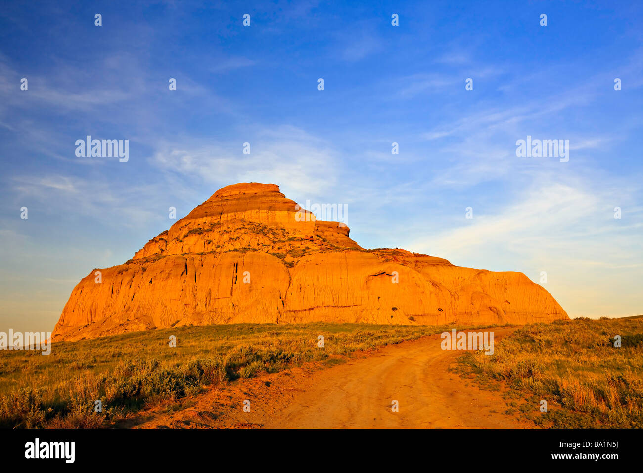 Road leading to Castle Butte during sunset in the Big Muddy Badlands ...