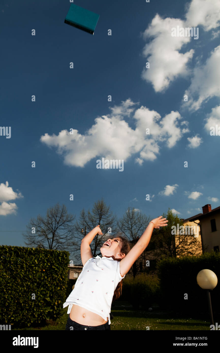 Child celebrating end of schoolyear throwing a book in the air Stock ...