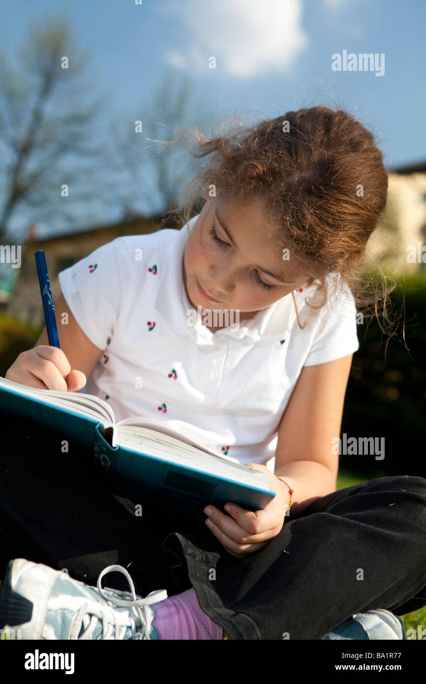 Young girl doing her homework in the garden Stock Photo - Alamy