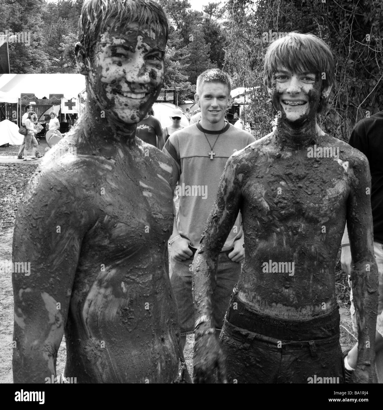 2 teenage boys smiling at the camera after playing in the mud with ...