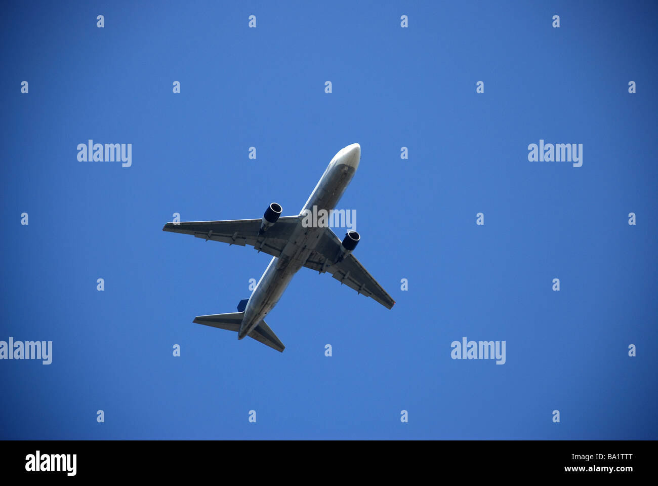 Passenger Jet flying in blue sky Stock Photo - Alamy