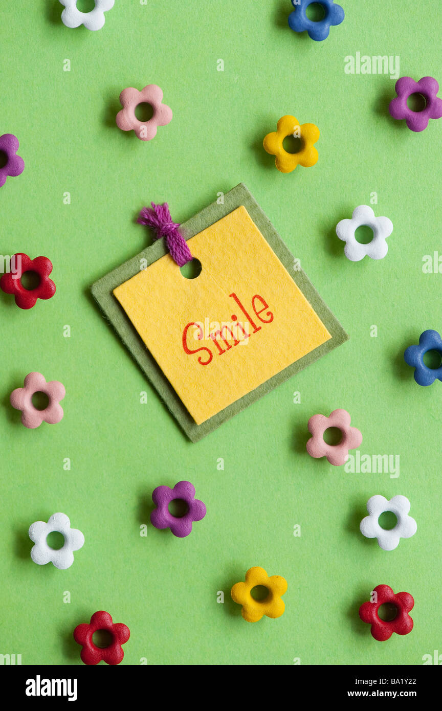 Smile label and flower shapes on green background Stock Photo - Alamy