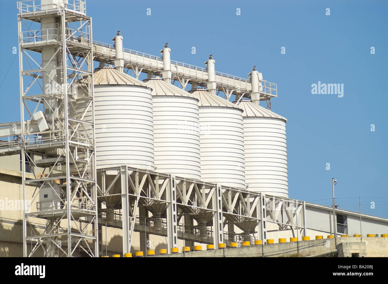 Close up of four white silos against clear blue sky Stock Photo - Alamy