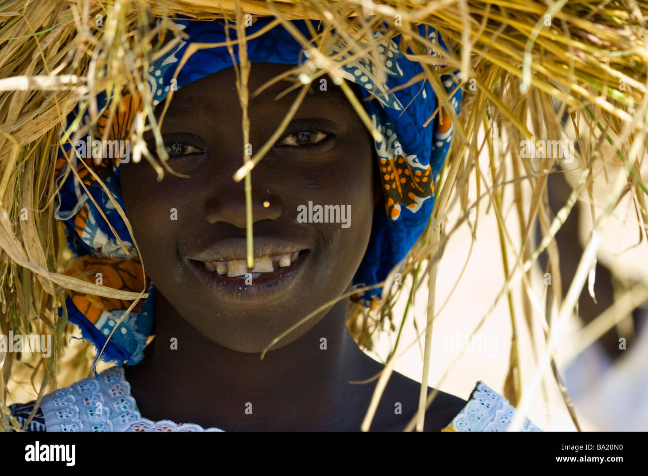Young Malian girl carrying straw on her head in Djenne Mali Stock Photo ...