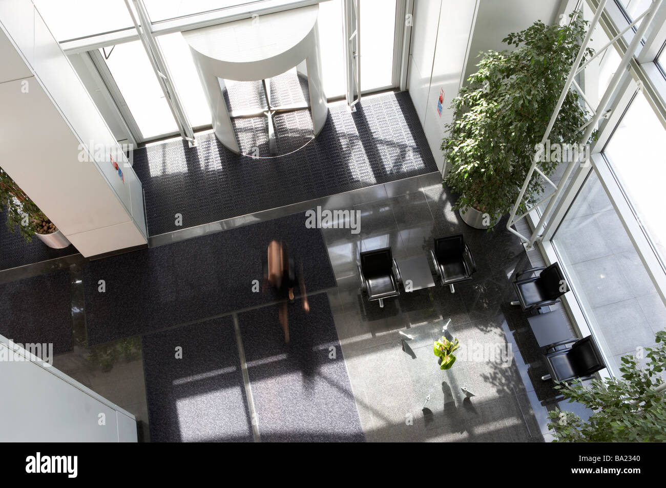 Woman walking into Office reception and lobby through revolving door ...