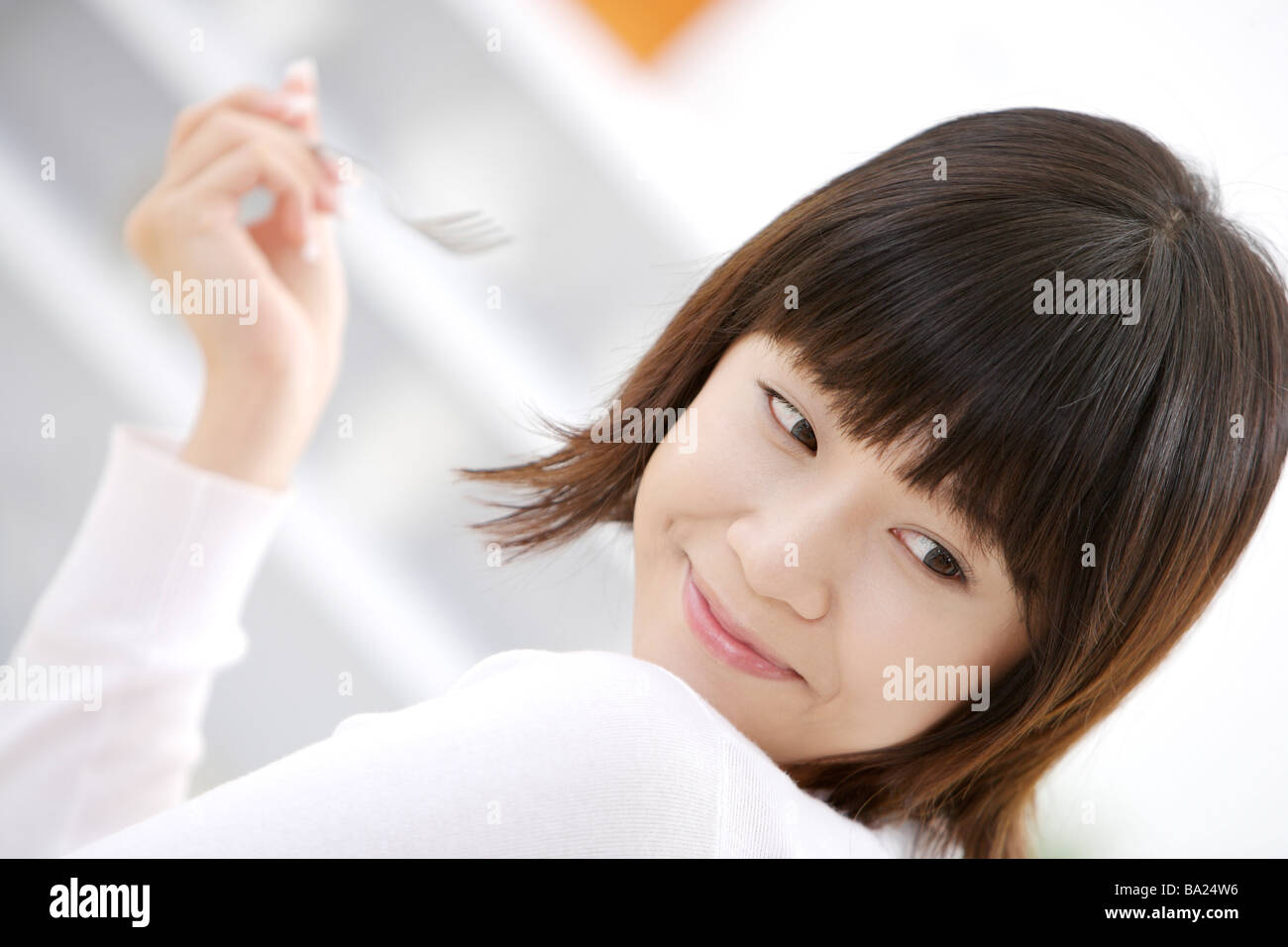 Portrait of young woman looking back smiling Stock Photo - Alamy