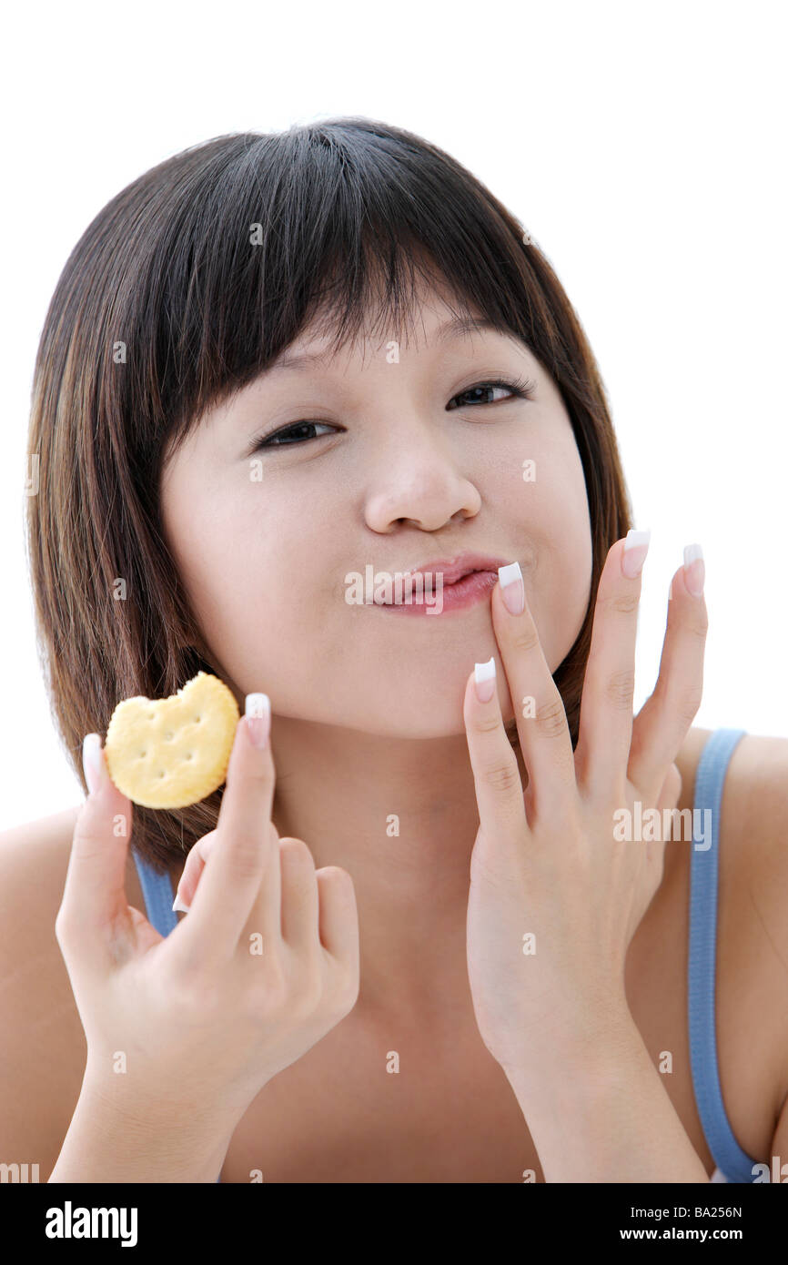 Young woman eating biscuit smiling close up looking at camera Stock ...