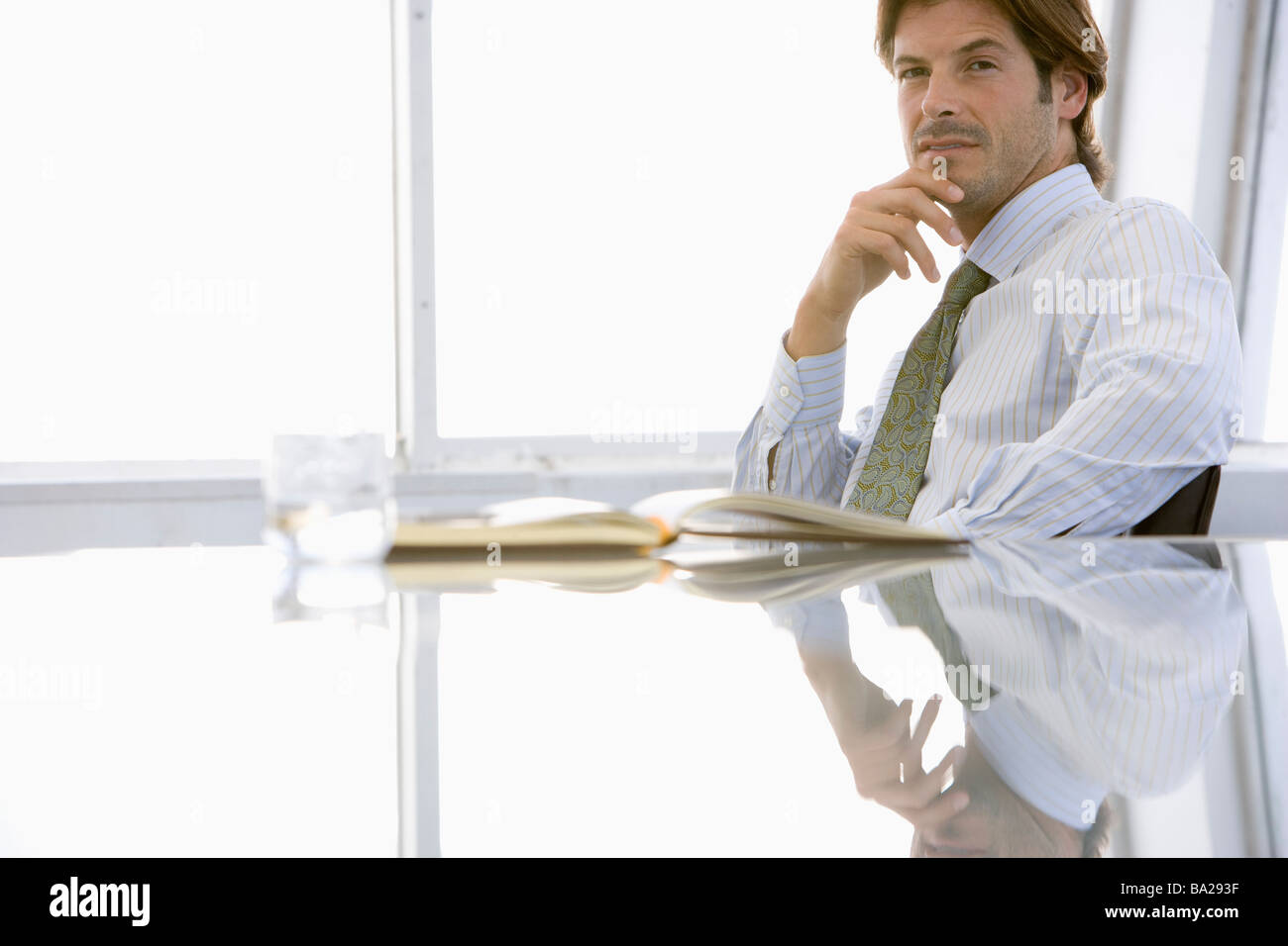 Business man sitting at conference table, portrait Stock Photo - Alamy