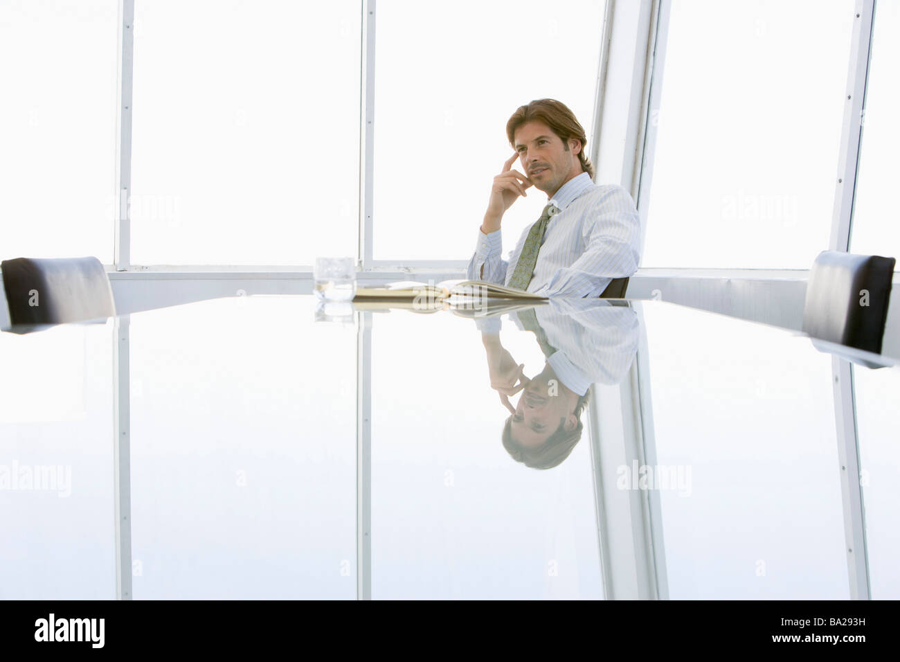 Business man sitting at conference table Stock Photo - Alamy