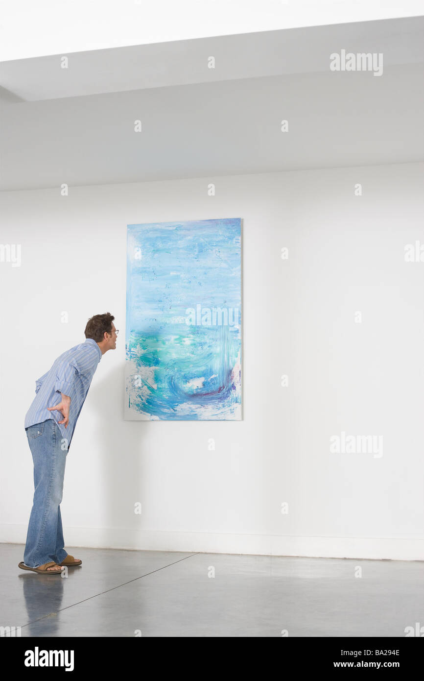 Man contemplating paintings in gallery Stock Photo - Alamy