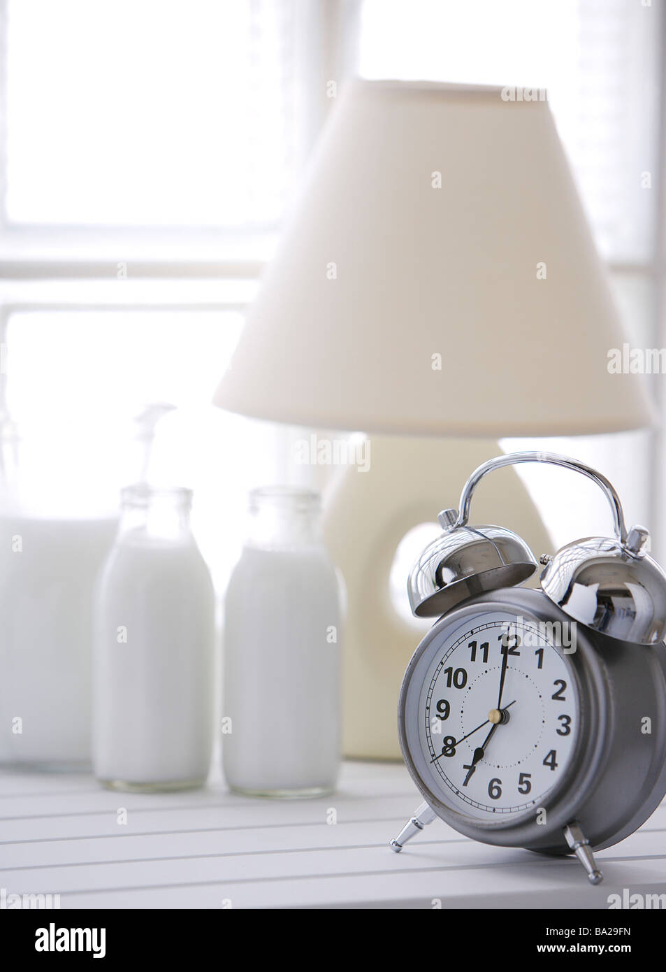 Alarm clock glass bottles of milk and lamp close up Stock Photo - Alamy