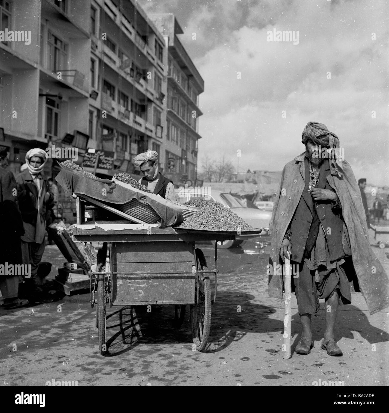 1950s, historical, a bearded Afghan man with a stick and ragged clothes ...