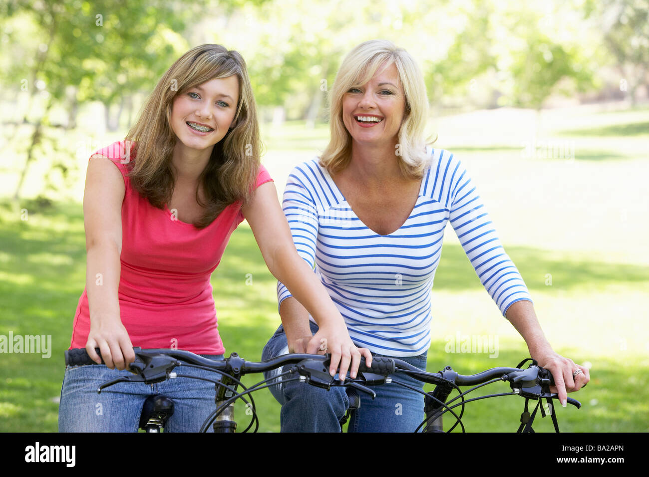 Mother And Daughter Cycling Through A Park Stock Photo - Alamy