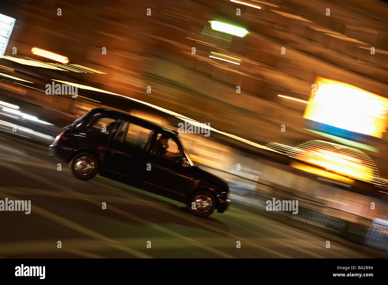 Taxi Driving Through Night Time Street Stock Photo - Alamy
