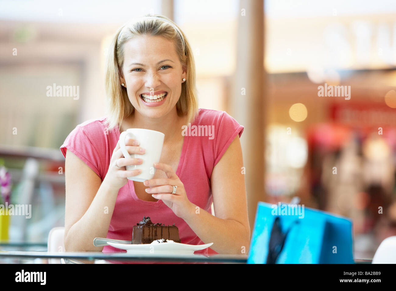 Woman Eating A Piece Of Cake At The Mall Stock Photo - Alamy