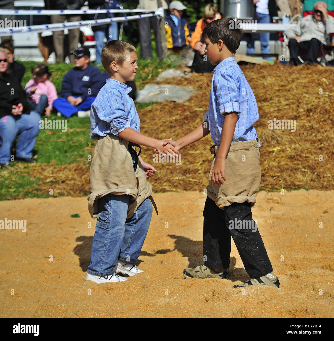 Two Swiss children shaking hands before a bout of Swiss wrestling ...