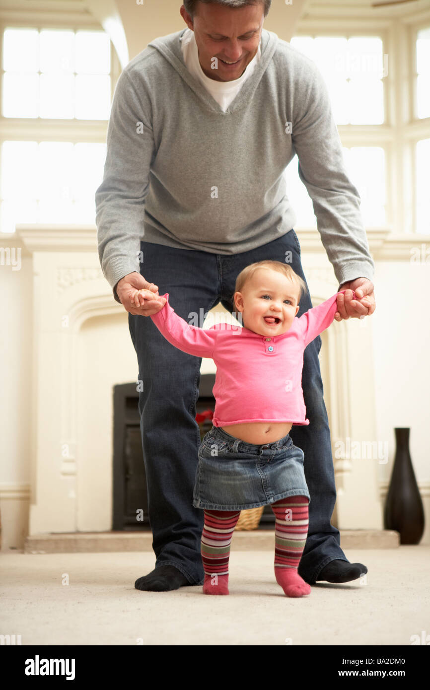 Father Helps Baby Daughter With Walking Stock Photo - Alamy