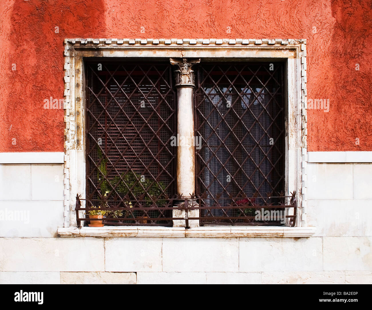 Window and ironwork grate with improvised window box and pot plants ...