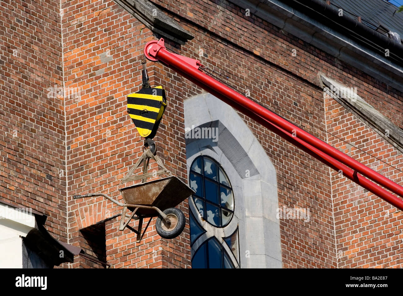 Crane lifting wheelbarrow in front of church Stock Photo - Alamy