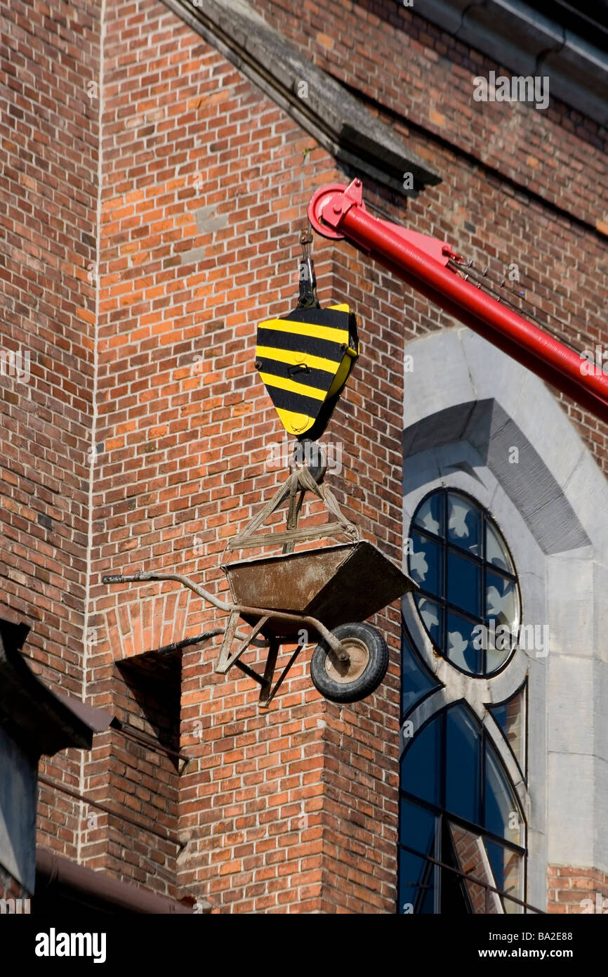 Crane lifting wheelbarrow in front of church Stock Photo - Alamy