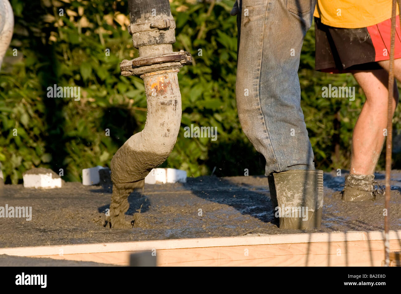 Construction workers pouring concrete at construction site Stock Photo ...