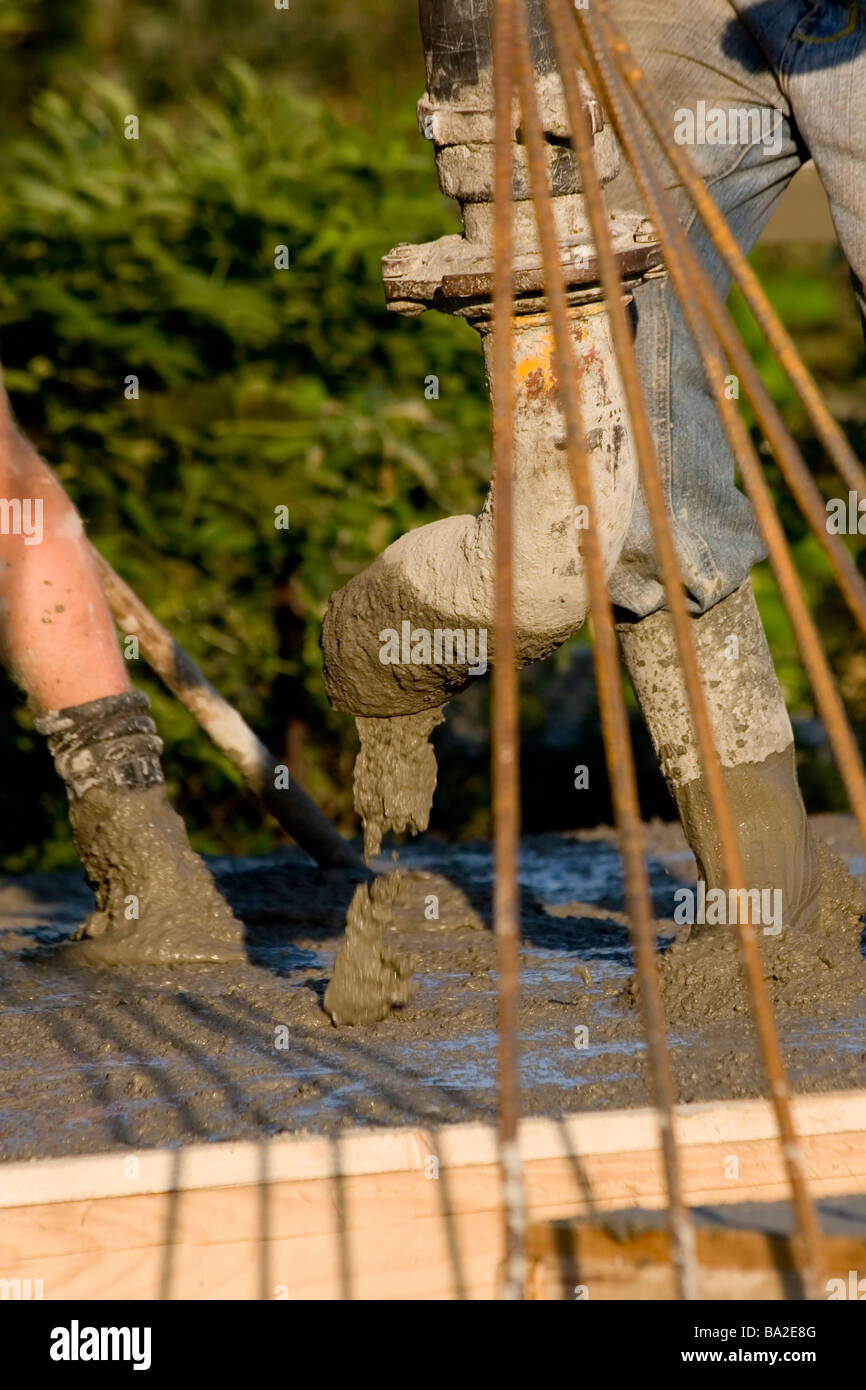 Construction workers pouring concrete at construction site Stock Photo ...