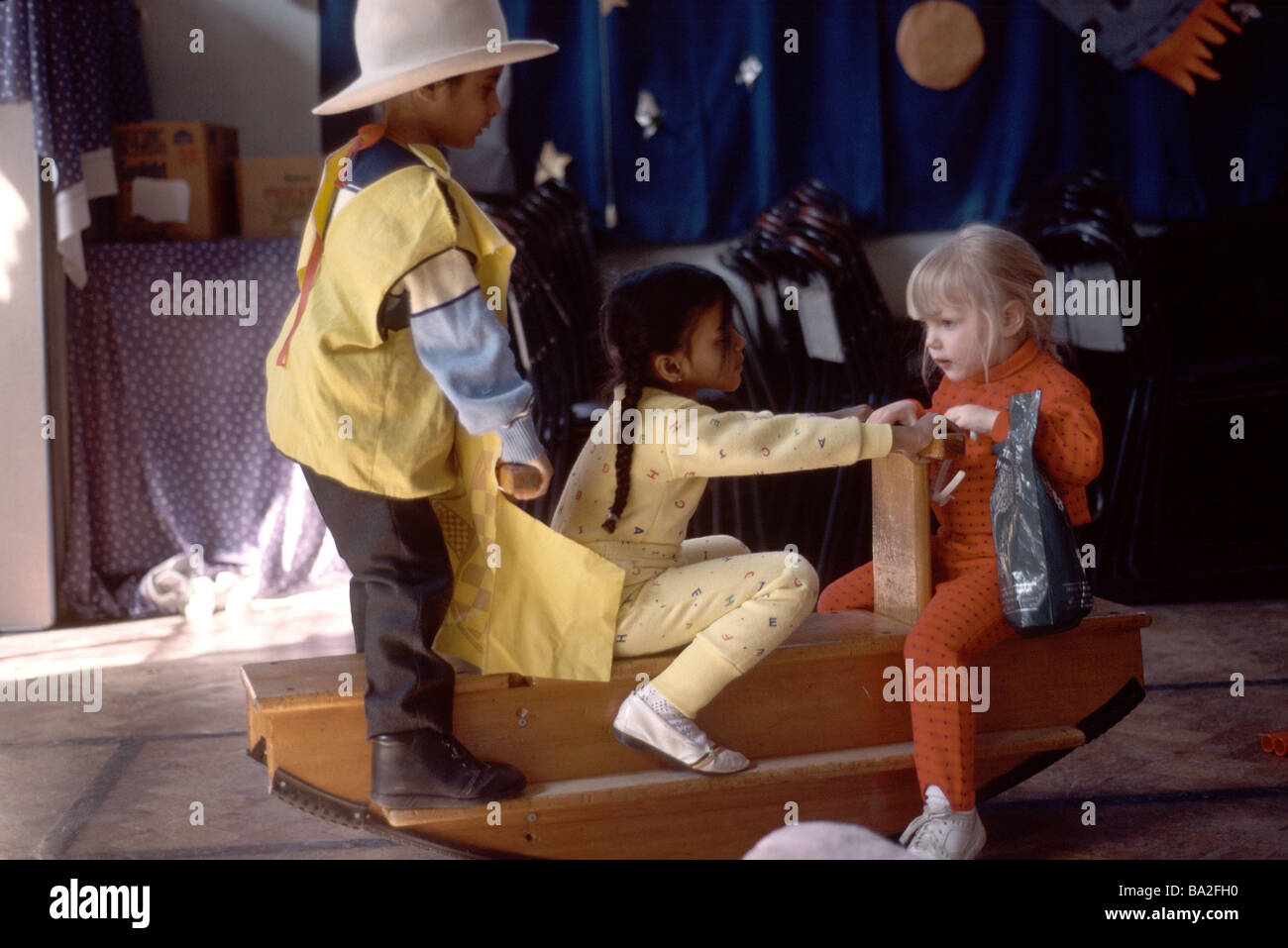 children playing on a see-saw in nursery school Stock Photo - Alamy
