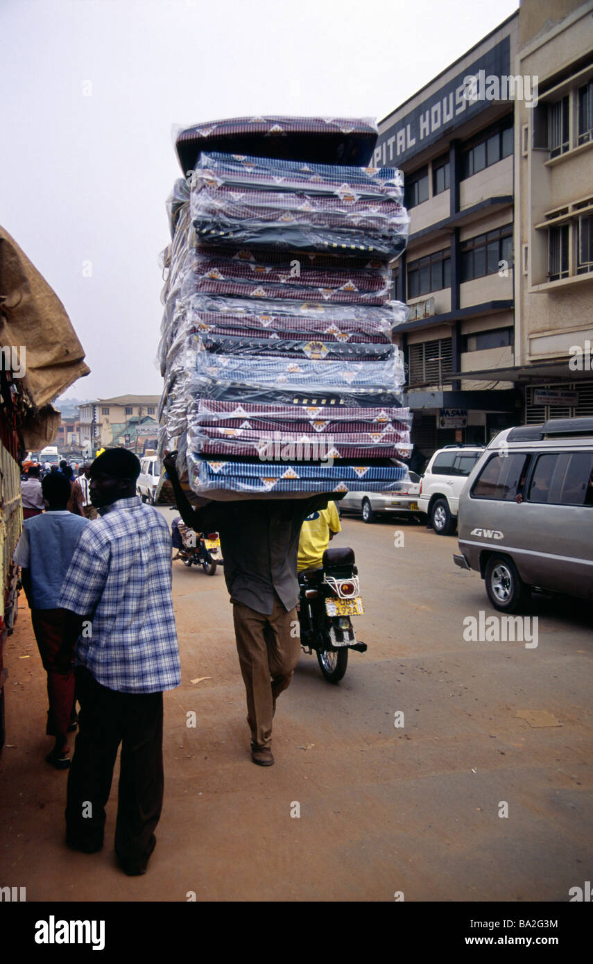Man carrying a big stack of mattresses Stock Photo - Alamy