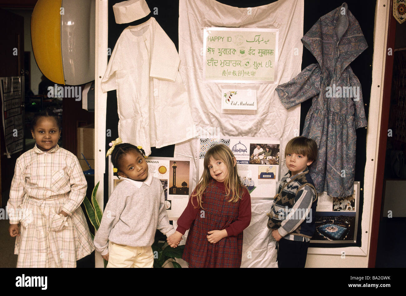 Nursery school children standing in front of of an Eid festival display ...
