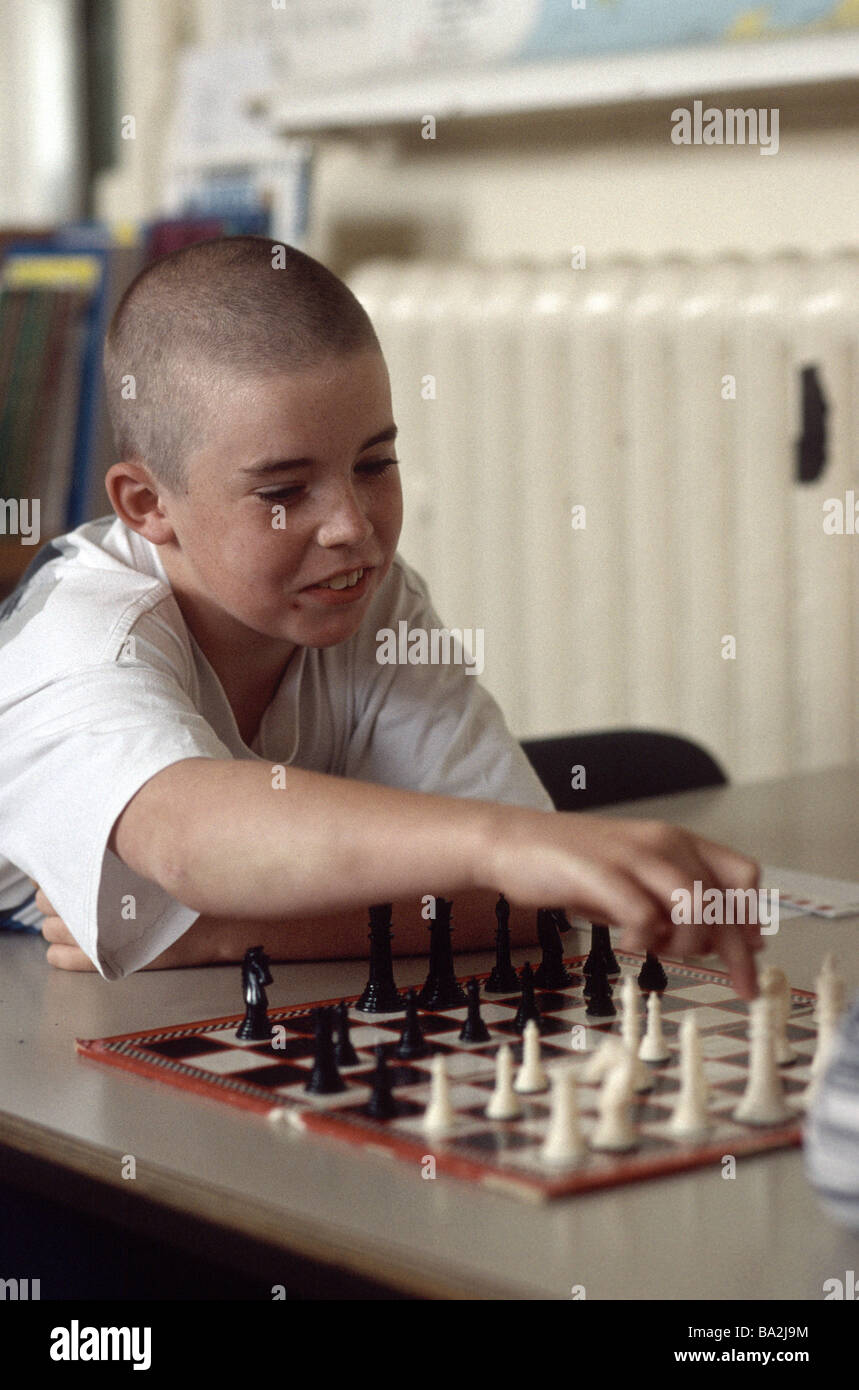 young school boy playing chess in the classroom Stock Photo - Alamy