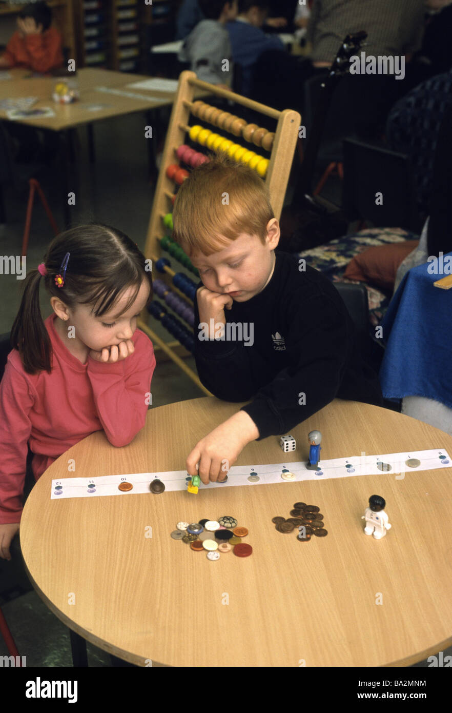 Primary school boy and girl playing with buttons and coins Stock Photo ...