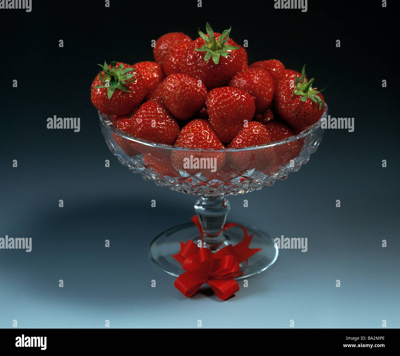 overflowing bowl of red strawberries against dark background Stock ...